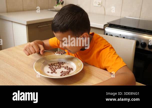 Boy eating granola with milk for breakfast. Nutritious and healthy ...