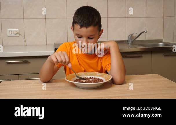 Boy eating granola with milk for breakfast. Nutritious and healthy ...