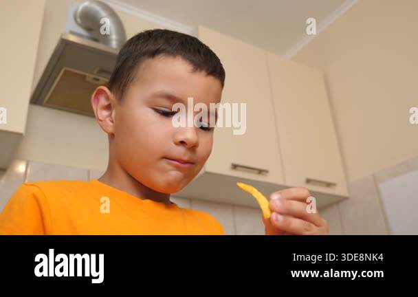 The boy is happily eating potato chips Stock Video Footage - Alamy