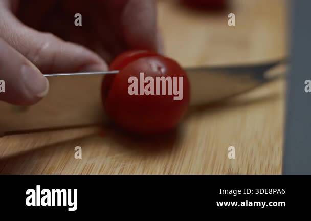 Cutting cherry tomatoes into halves Stock Video Footage - Alamy
