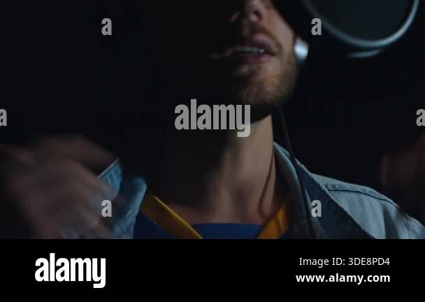 Male rap singer in headphones recording new song in a modern studio ...