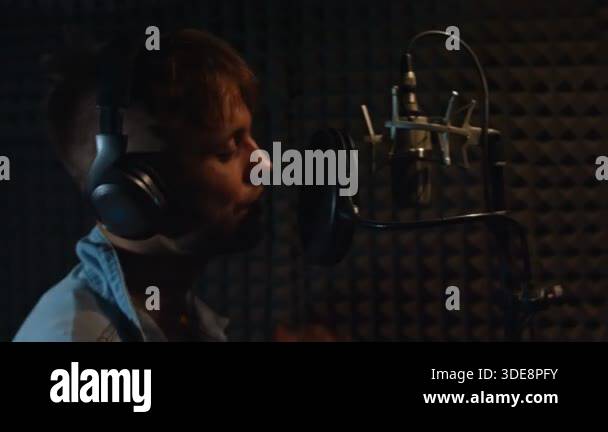 Handsome male rap singer in headphones with professional microphone ...