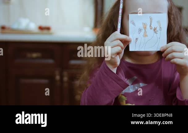 Small girl is showing her drawing with colored pencils learning ...