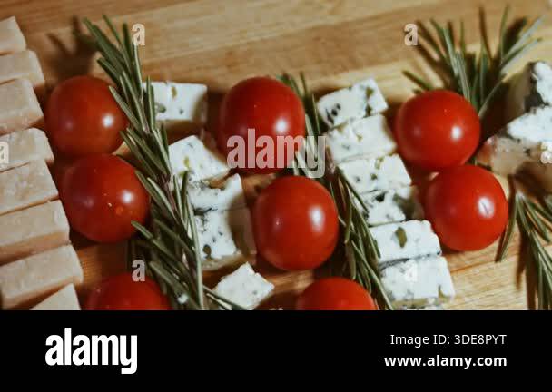 Appetizer with sliced soft cheese, parmesan and cherry tomatoes Stock ...
