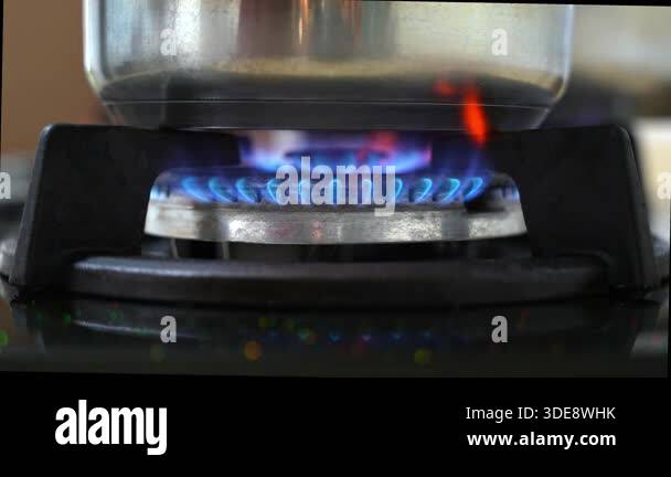 A burning Liquified Natural Gas LNG kitchen gas stove with a stainless ...