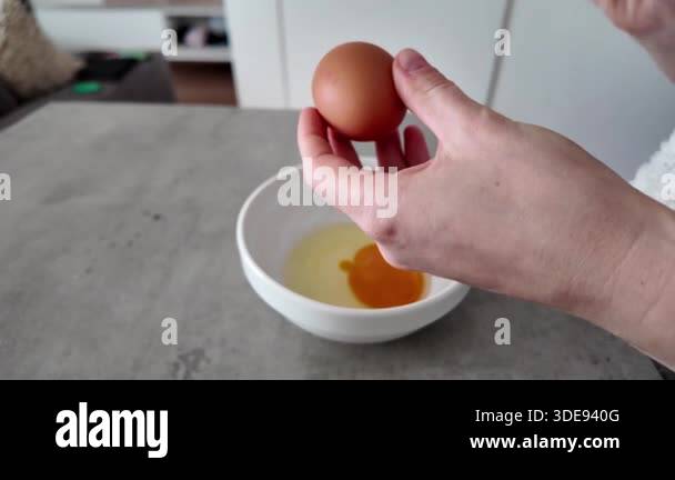 closeup white hands cracking eggs. home cook in cozy kitchen, stepwise ...