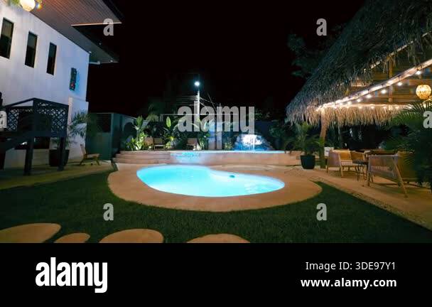 Beautiful resort hotel backyard with a glowing swimming pool and a ...