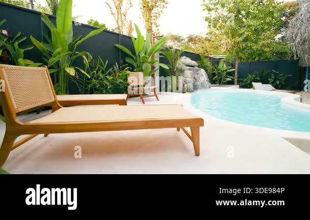 Elegant resort swimming pool area with modern lounge chairs. A tranquil ...