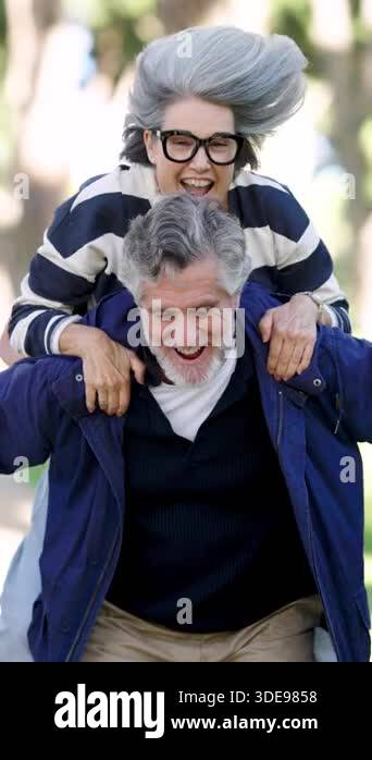 Cheerful senior couple enjoying a playful moment together in a park ...