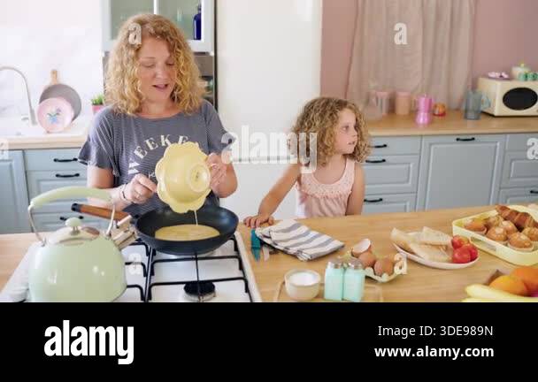 Happy family moment with a mother and her little daughter preparing ...