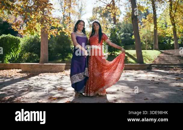 Two beautiful indian women wearing colorful traditional clothing ...
