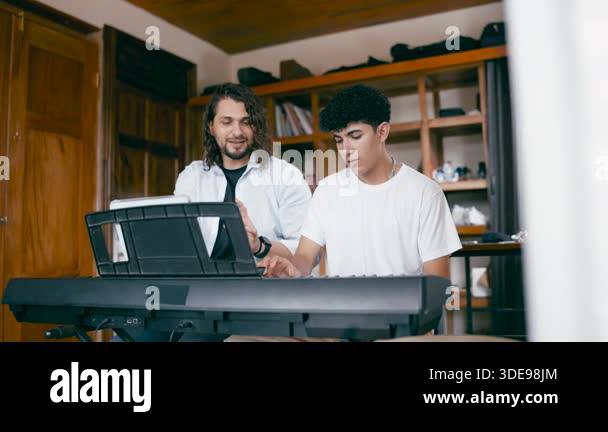 Professional male tutor teaching a young student how to play the ...