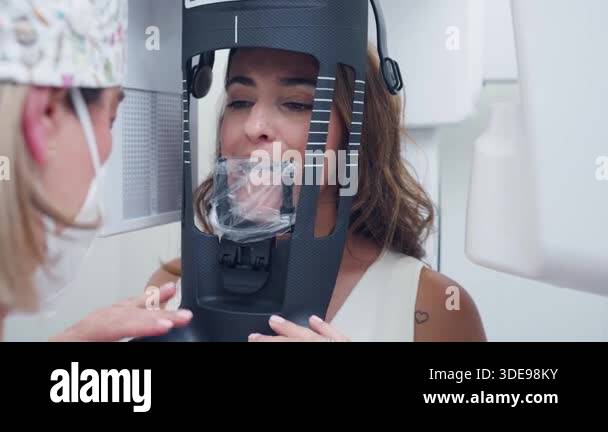Professional female dentist placing a patients head into a 3d dental ...