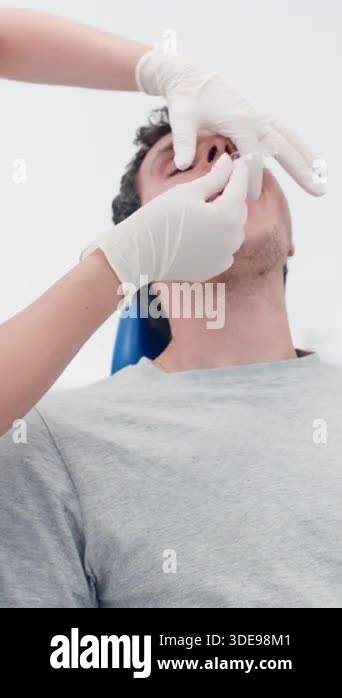 Orthodontist wearing protective gloves placing a transparent aligner on ...