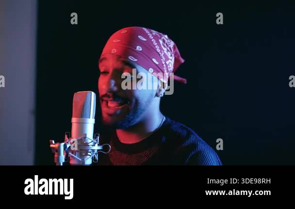 Passionate male singer with a red bandana performing a reggaeton song ...
