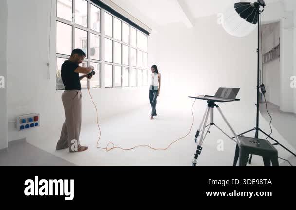 Professional photographer capturing fashion model during stylized ...