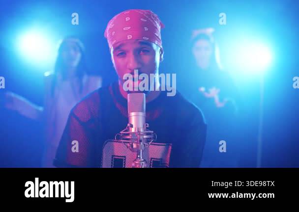 Male artist singing a song into a microphone during a live performance ...