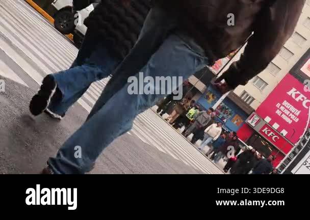 Pedestrians carrying shopping bags while crossing a major avenue ...