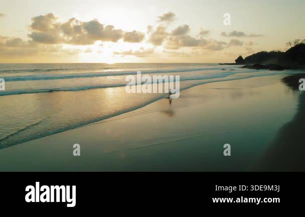 Woman with long hair walking on water during sunset on reflective ...