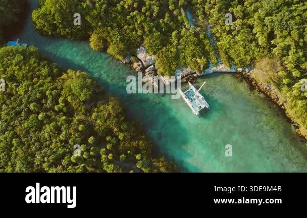 Aerial view of catamaran anchored in narrow turquoise Crocodile Lagoon ...