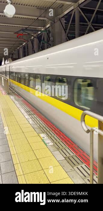 A Shinkansen high-speed train arrives at a platform at a Japan Railway ...