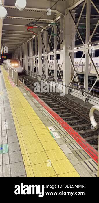 A Shinkansen high-speed train arrives at a platform at a Japan Railway ...