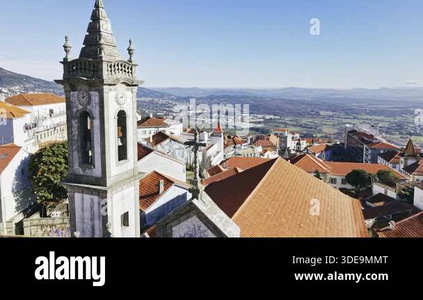 Aerial view of Covilha old town with church tower, red tile roofs and ...