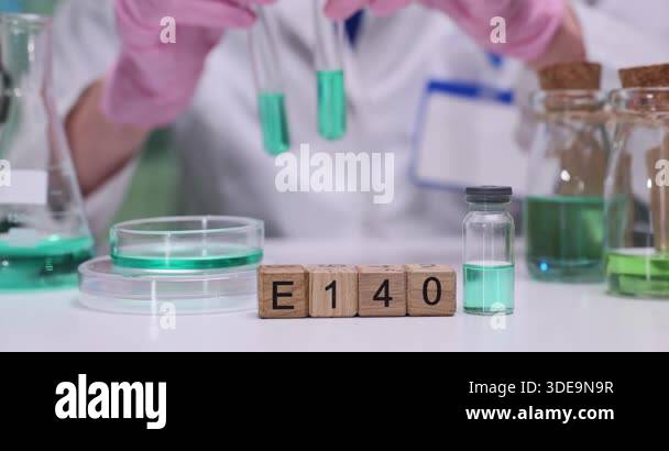 Wooden blocks on laboratory bench spell code E140 near green reagent ...