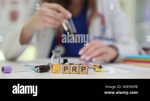 Wooden blocks spell abbreviation PRP beside tubes with dark blood ...