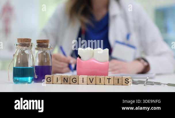 Wooden blocks spell word Gingivitis near dental gum model and blue ...
