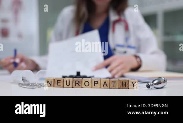 Wooden blocks spell word Neuropathy near shiny stethoscope. Woman ...