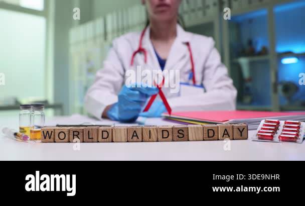 Wooden blocks spell words World AIDS Day on medical desk. Female doctor ...
