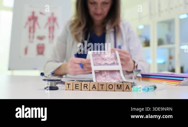 Wooden blocks on medical table spell word Teratoma near syringe. Woman ...