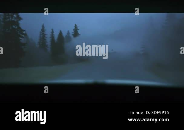 A mesmerizing sequence of a car driving through a foggy landscape ...
