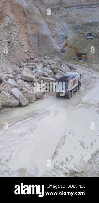 excavator loading large rocks into truck, hydraulic arm scooping ...