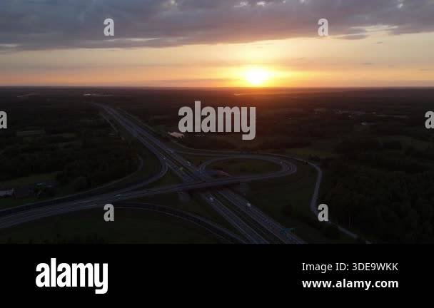 Aerial sunset view of a highway interchange cutting through forest ...
