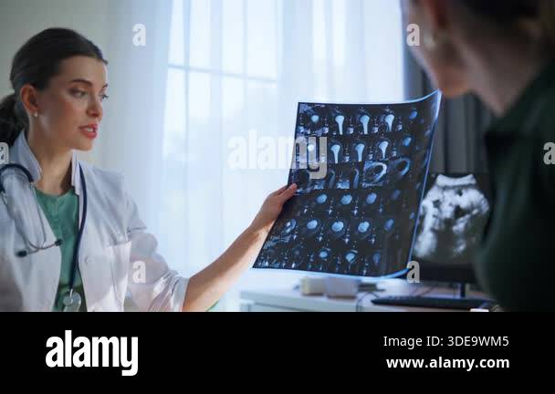 Practitioner explaining x-ray results closeup. Happy patient smiling at ...