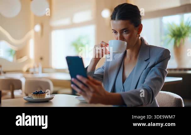 Smiling business owner enjoying coffee in modern city restaurant ...
