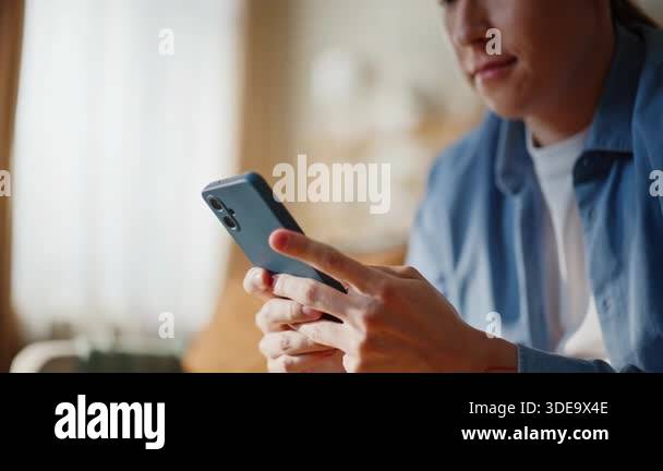 Closeup man fingers tapping smartphone message at couch living room ...