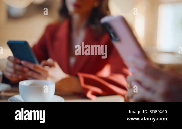 Manicured hands holding cellphones in cafeteria closeup. Elegant two ...