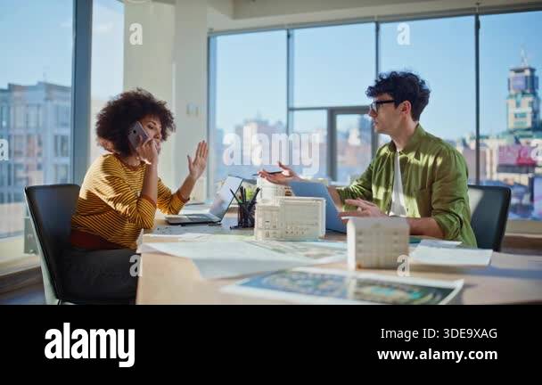 Worried team talking smartphone in construction agency office ...