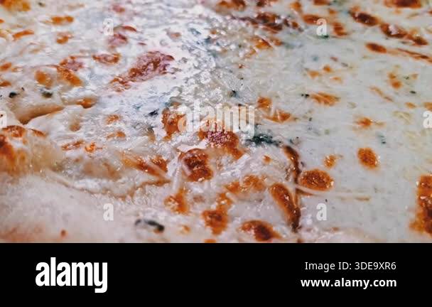 Macro view of a hot, freshly baked four cheese pizza. Melted mozzarella ...