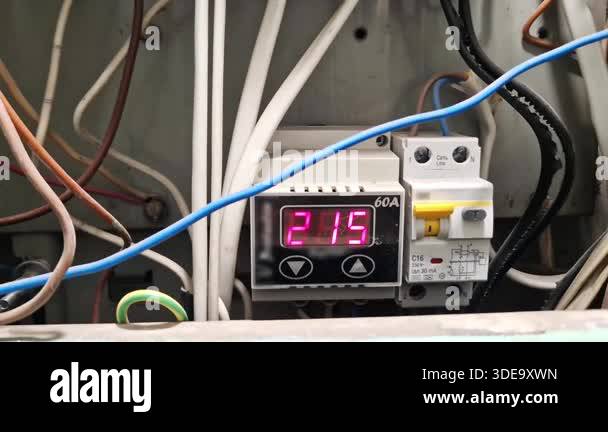 Close-up of a digital voltage meter with a glowing red display showing ...