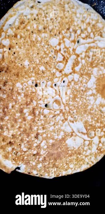 Vertical, top-down macro shot of a pancake with a porous, bubbly ...