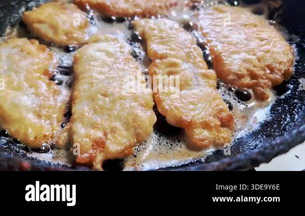 Extreme close-up of golden-brown breaded fish fillets sizzling and ...
