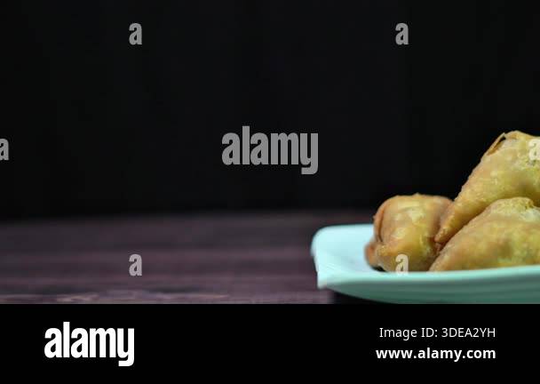 Crispy fried vegetable samosas served on a plate. Indian snack slide ...
