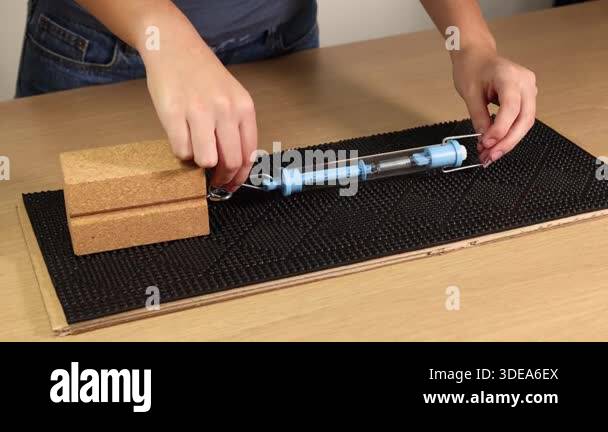 A wooden block is dragged across a surface using a spring scale ...