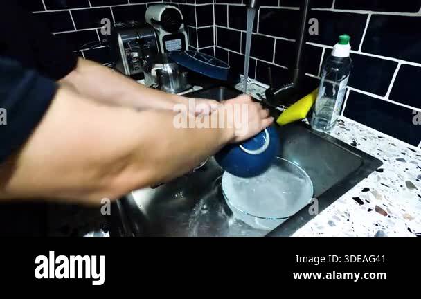 Person washing a blue dish in sink Stock Video Footage - Alamy