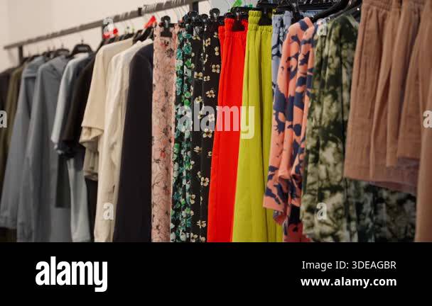 Colorful collection of womens clothing on hangers in the interior of a ...