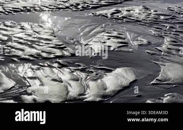 Low tide mudflat seascape with shimmering sunlight reflections on wet ...